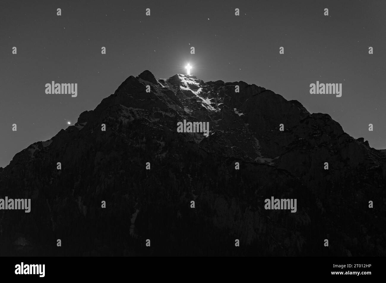 A scenic view of a glowing cross on top of a snow-capped mountain at ...