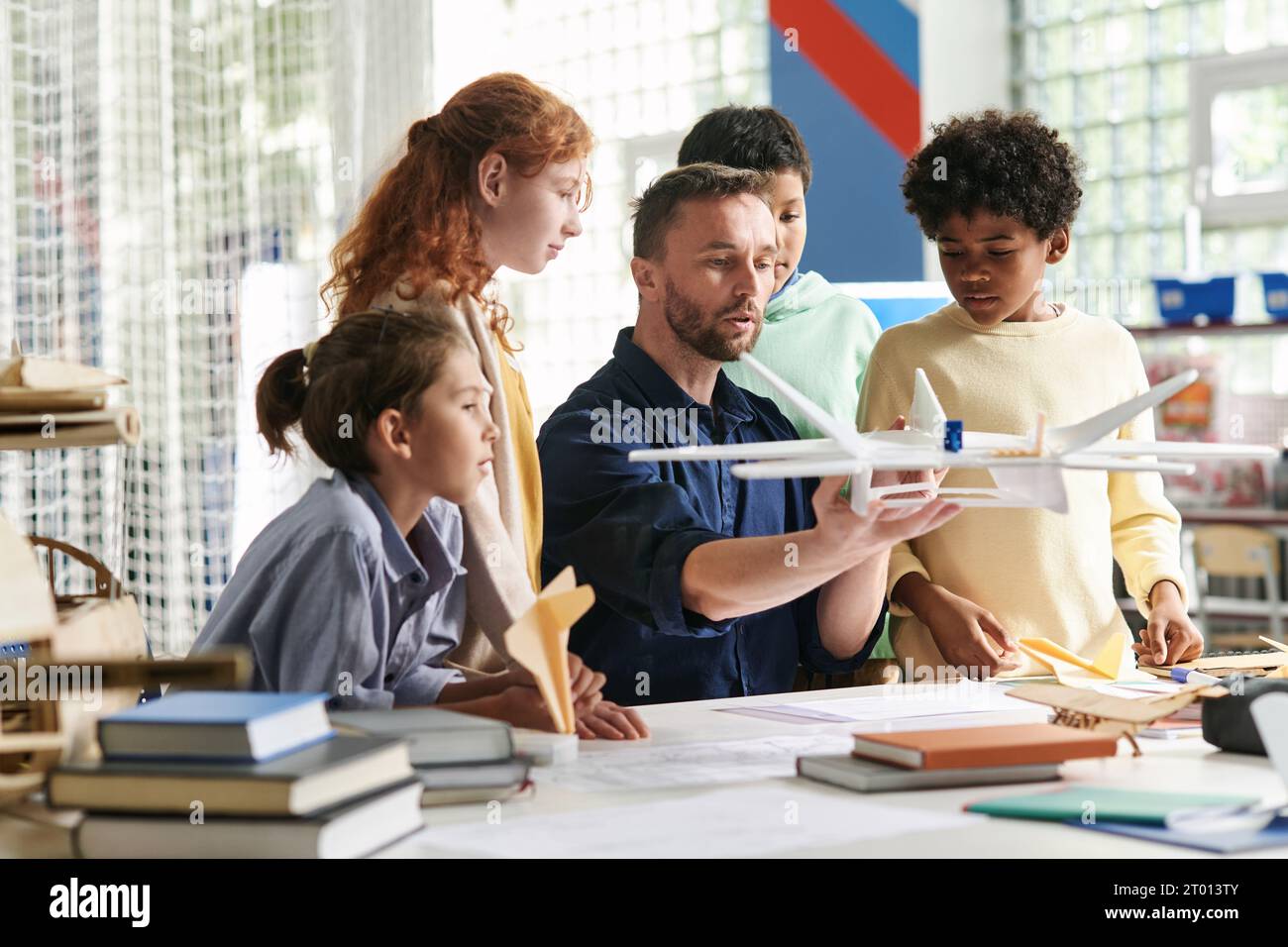 Teacher looking at plane assembled by his students Stock Photo - Alamy