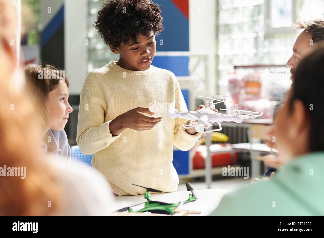 Boy trying to explain how quadcopter works in science class Stock Photo ...