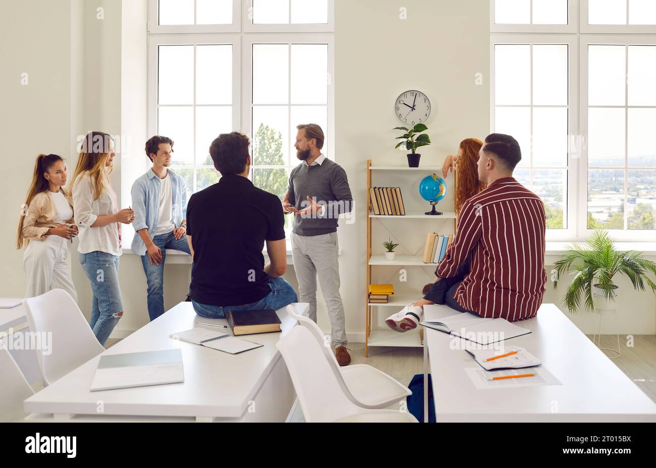 Professor is talking with group of students in audience during break ...