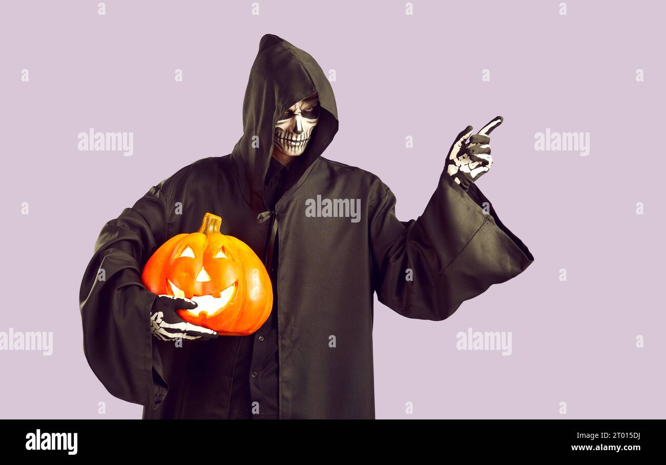 Man in costume of Death or Skeleton holding Halloween jack o lantern ...