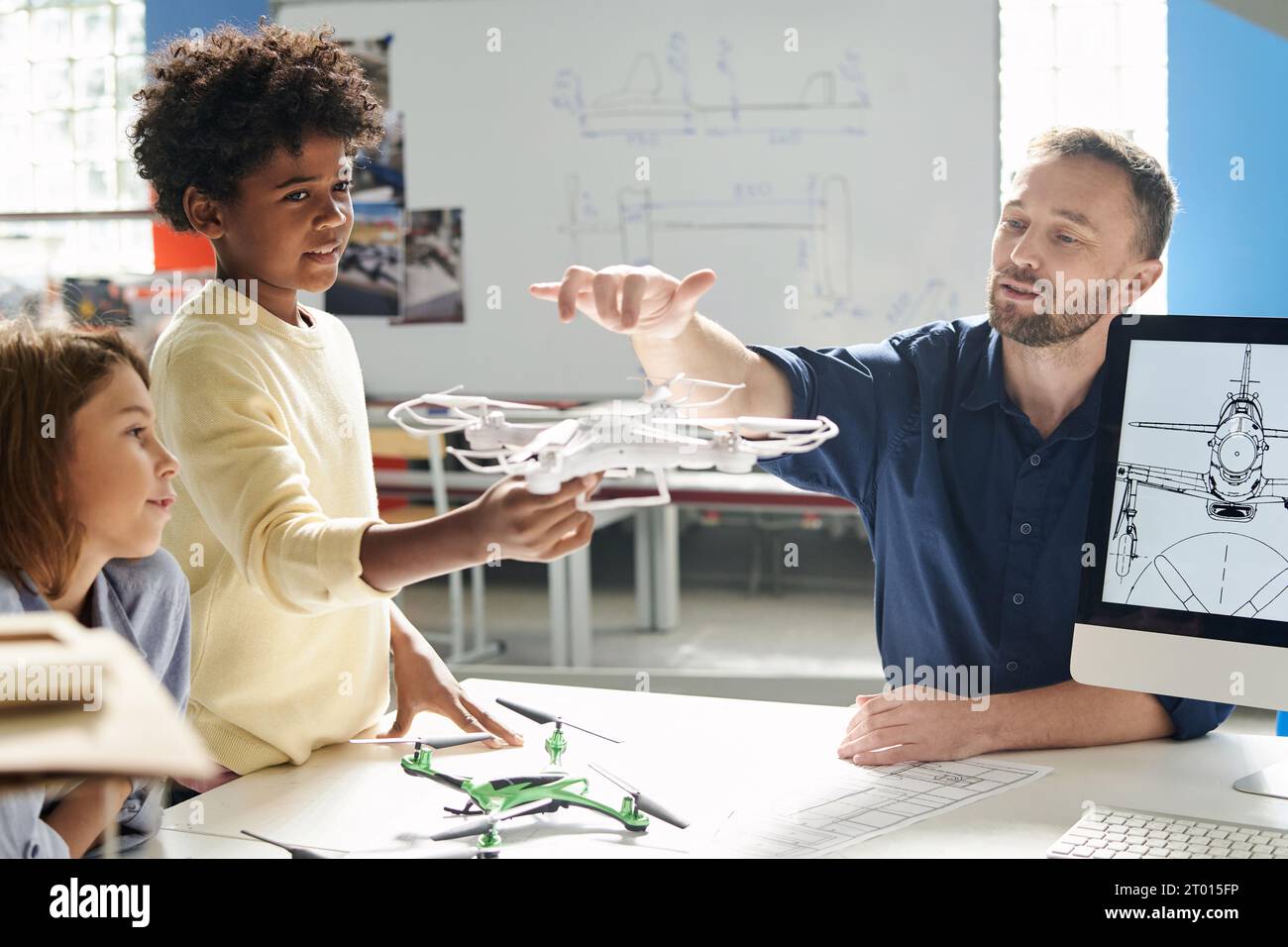 Aeromodeling class teacher explaining schoolkid how quadcopter fly ...