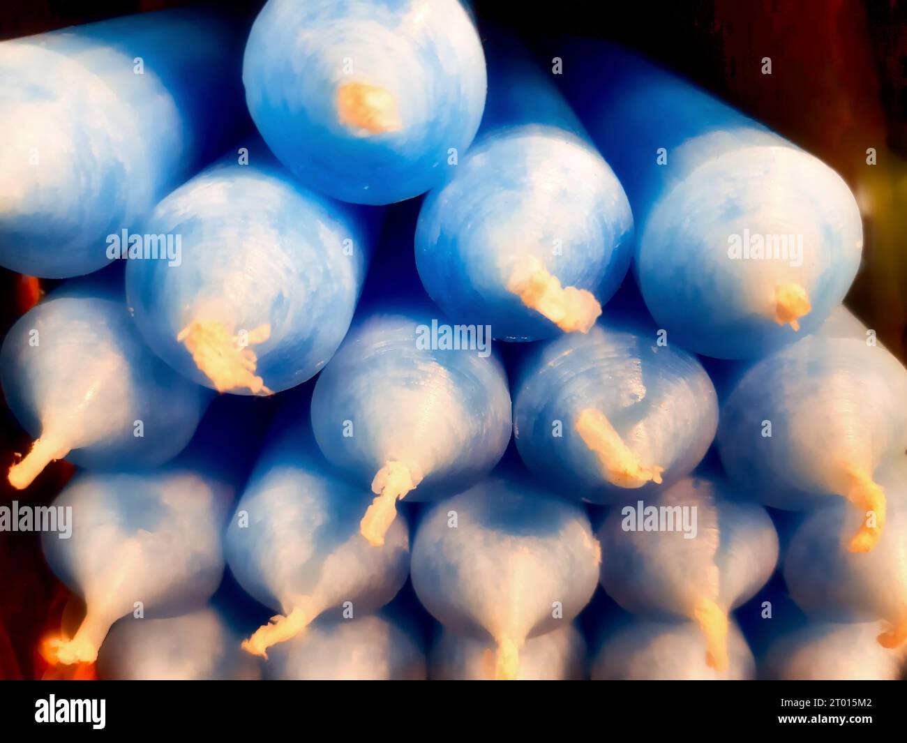 set of blue wax candles with white wick in a row, close-up, top view. A ...