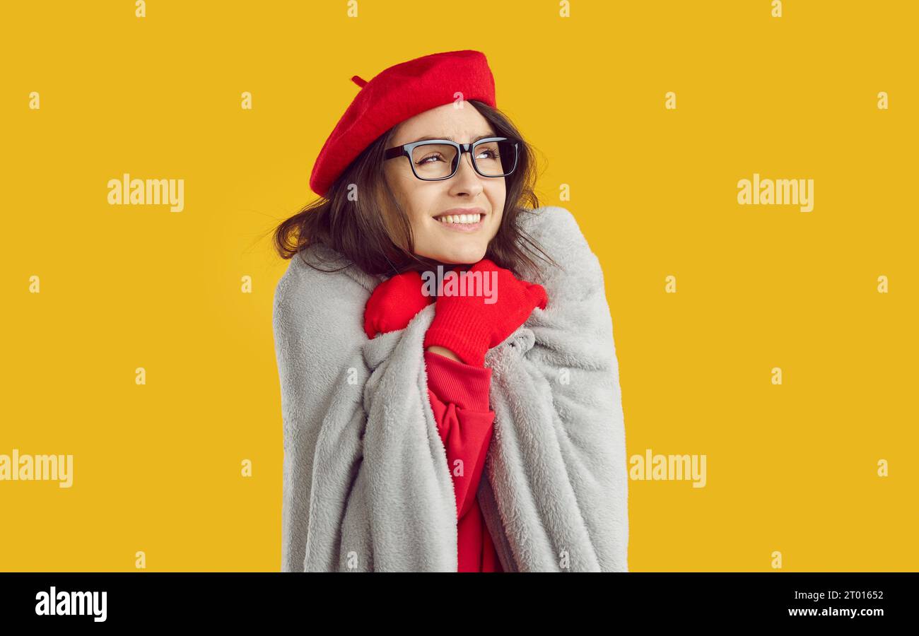 Woman freezing, shivering and wrapping herself in blanket in cold ...