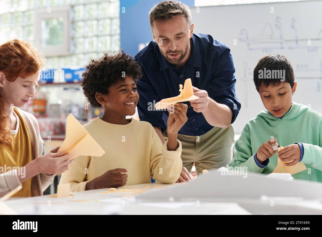 Teacher checking airplanes models made by students in his class Stock ...