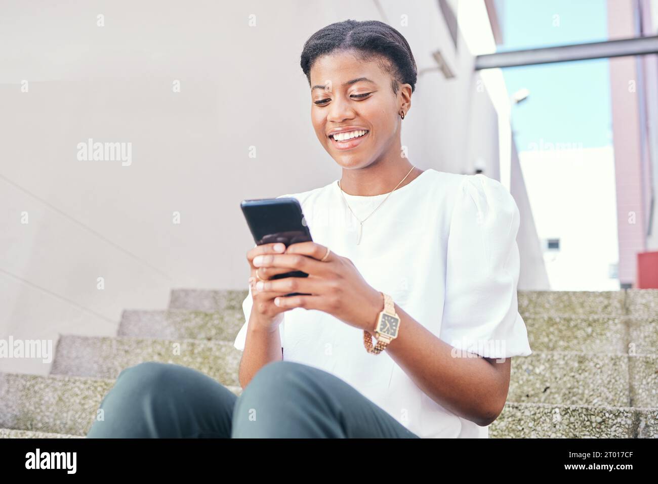 Phone, stairs and young woman in a building networking on social media ...
