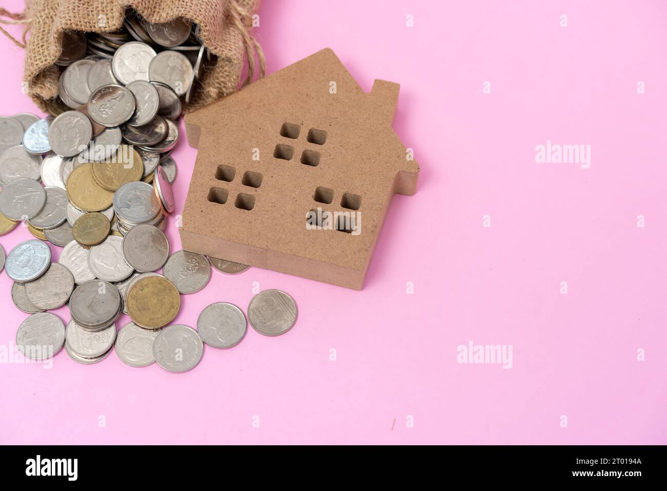Money stack with home on pastel pink background Stock Photo - Alamy