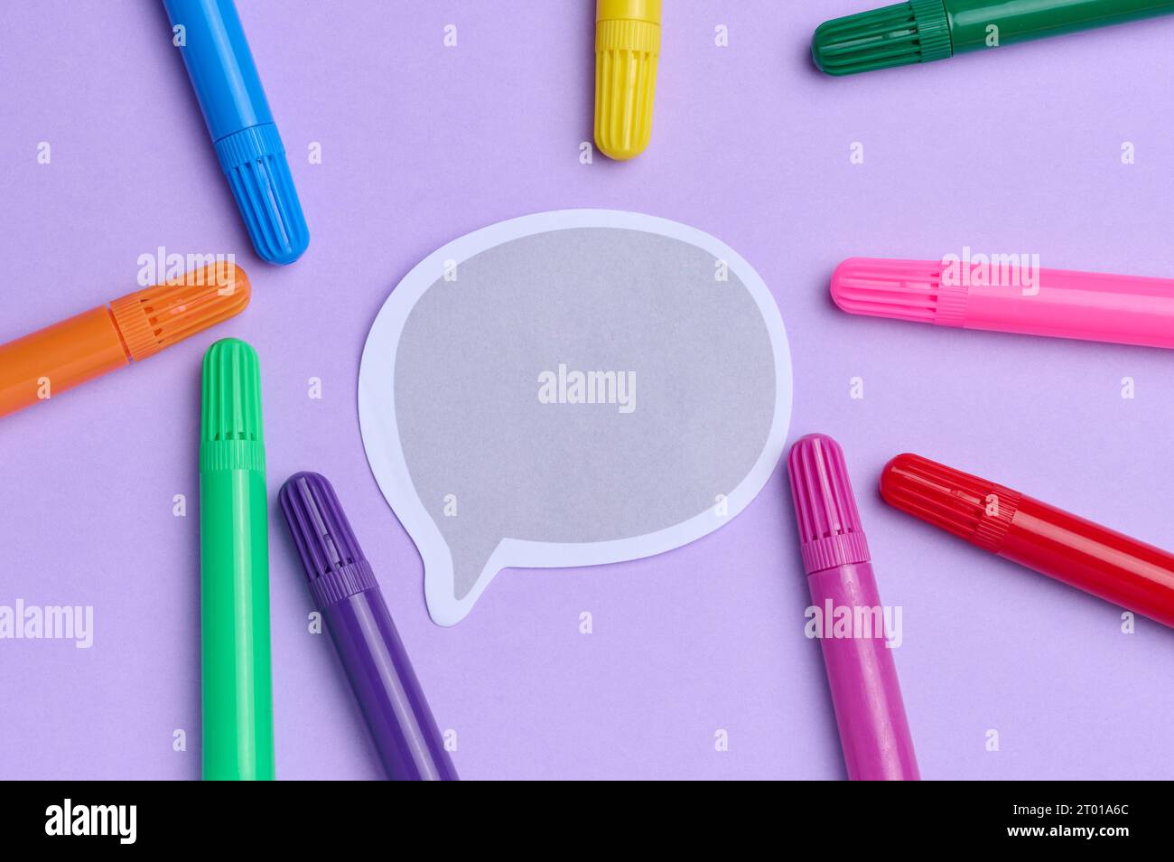 Paper sticker and multi-colored felt-tip pens on a green background ...