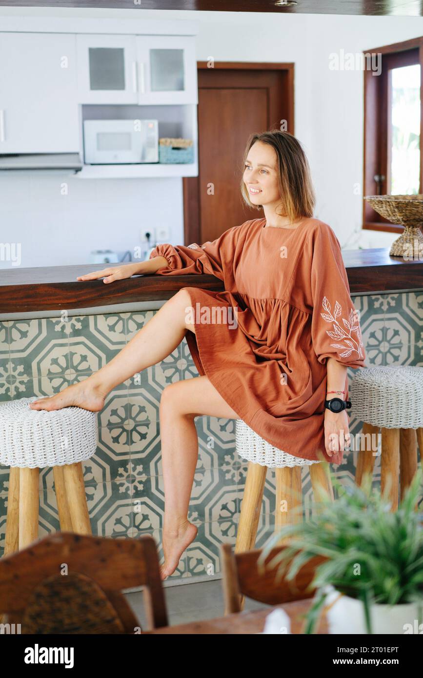 Barefoot woman in a beautiful dress sitting in a summer bar Stock Photo ...