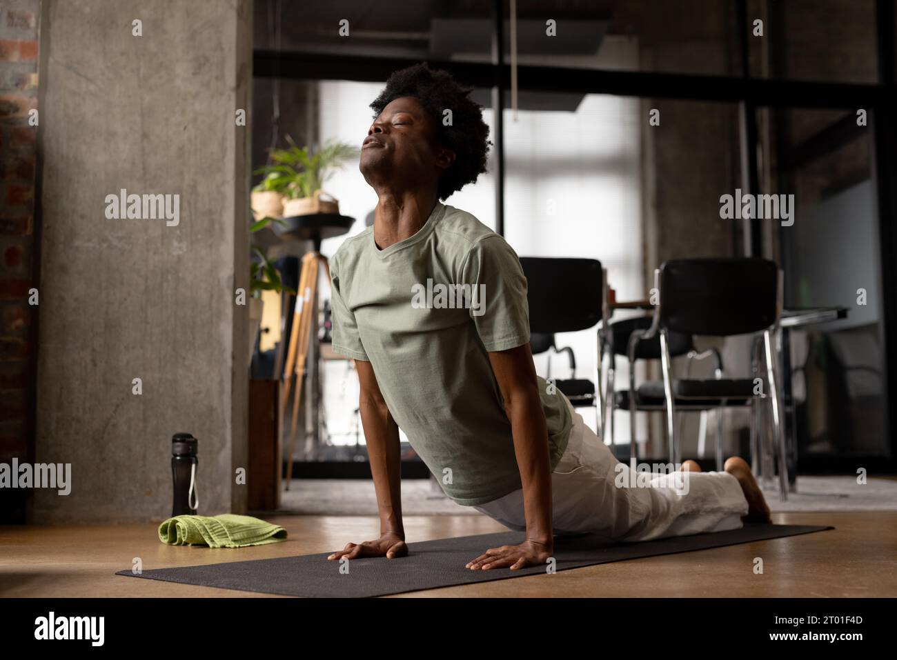 Happy relaxed african american man practicing yoga stretching on floor ...
