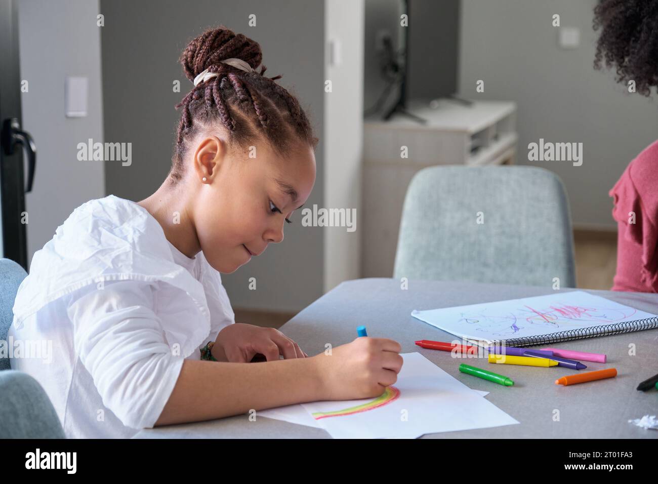 Braided hair girl painting a rainbow at home. Preteen girl drawing on ...