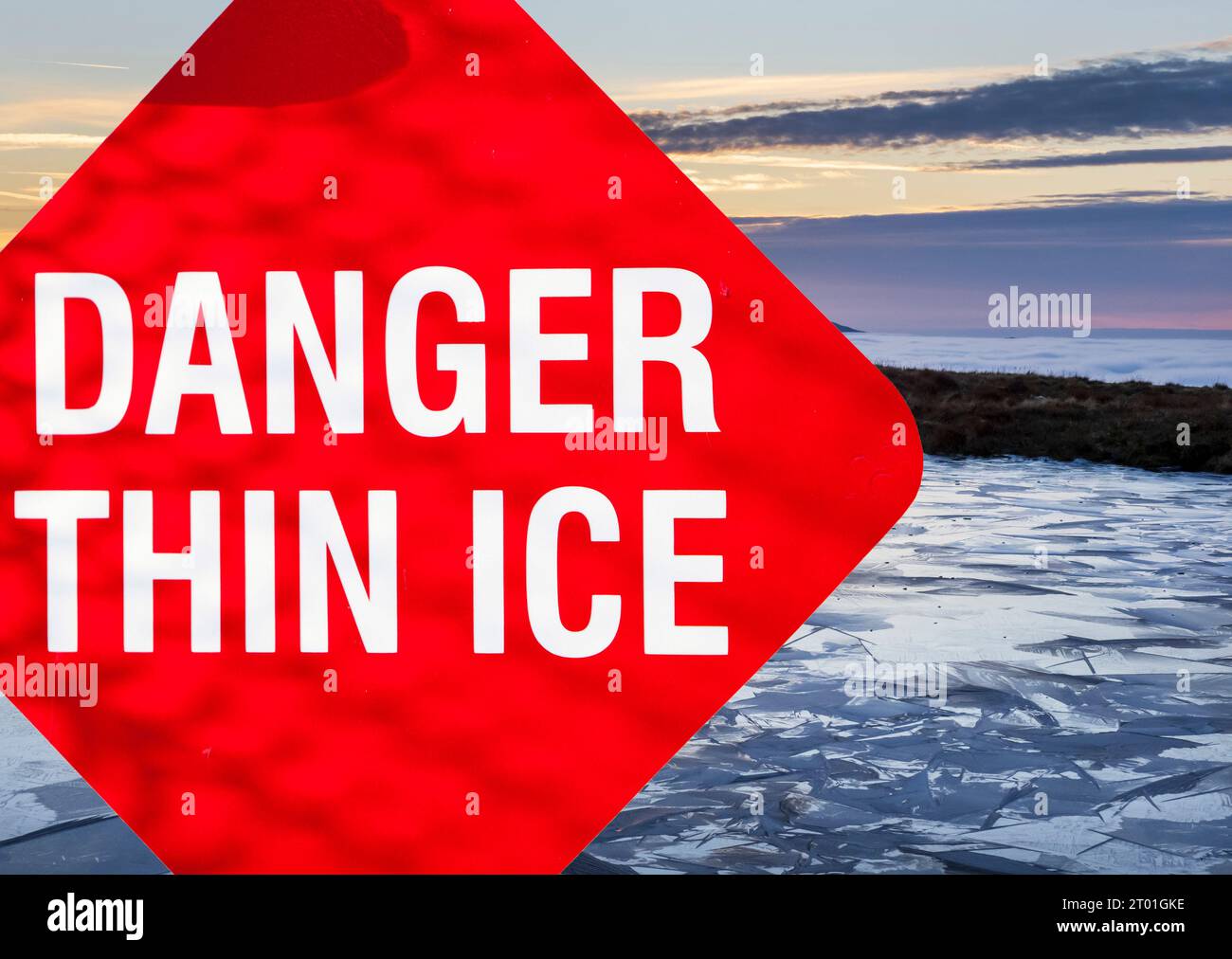 A mountaineer infront of Ice patterns on a frozen tarn on the summit of ...