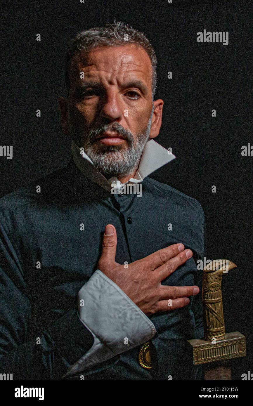Man dressed in black and white collar with serious gesture that looks ...