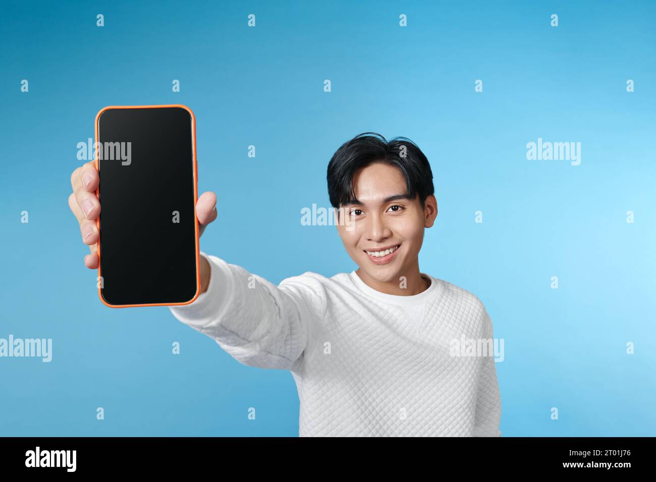 Satisfied confident smiling asian man showing mobile phone blank screen ...