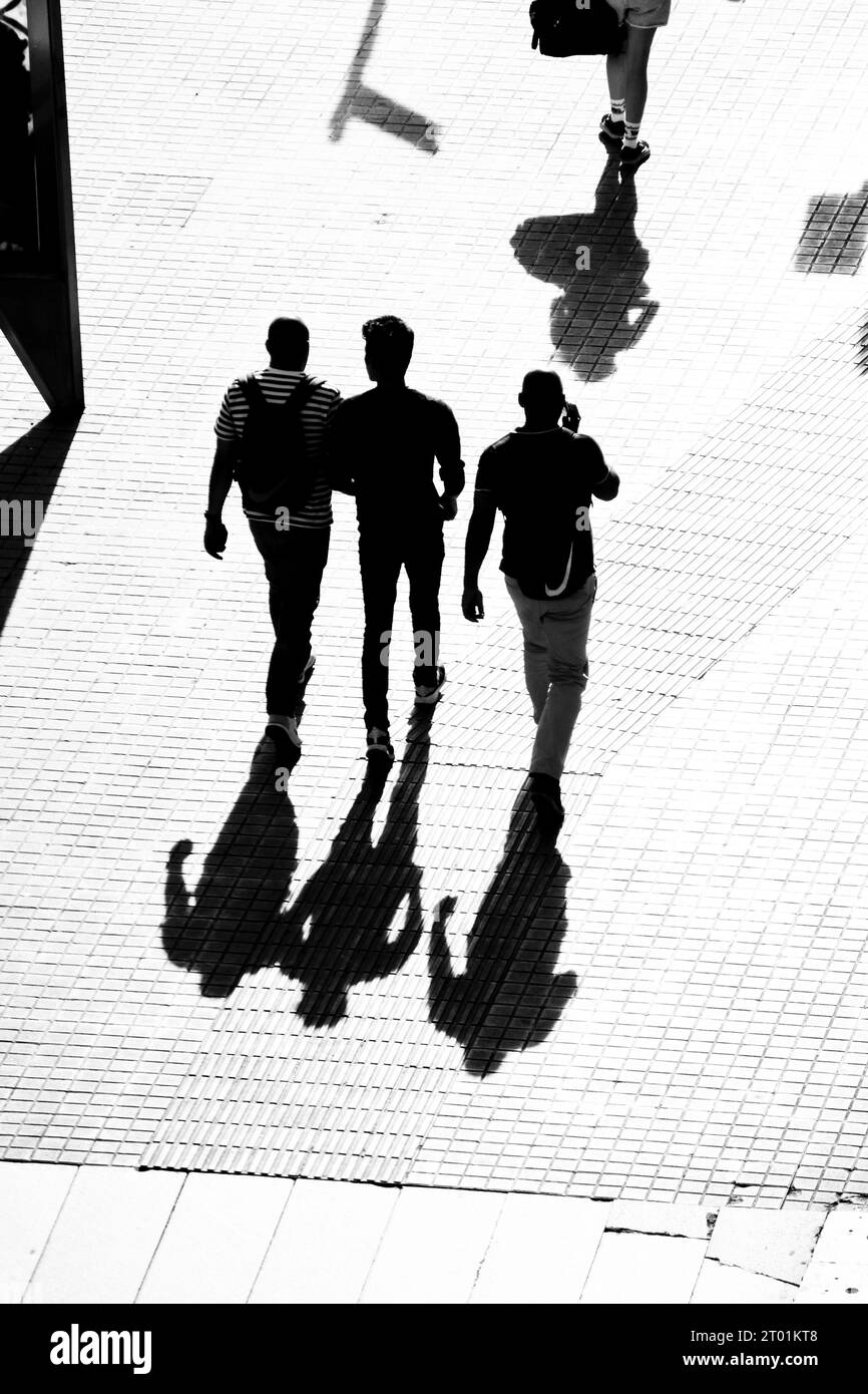 Silhouette of three men walking together on street Stock Photo - Alamy