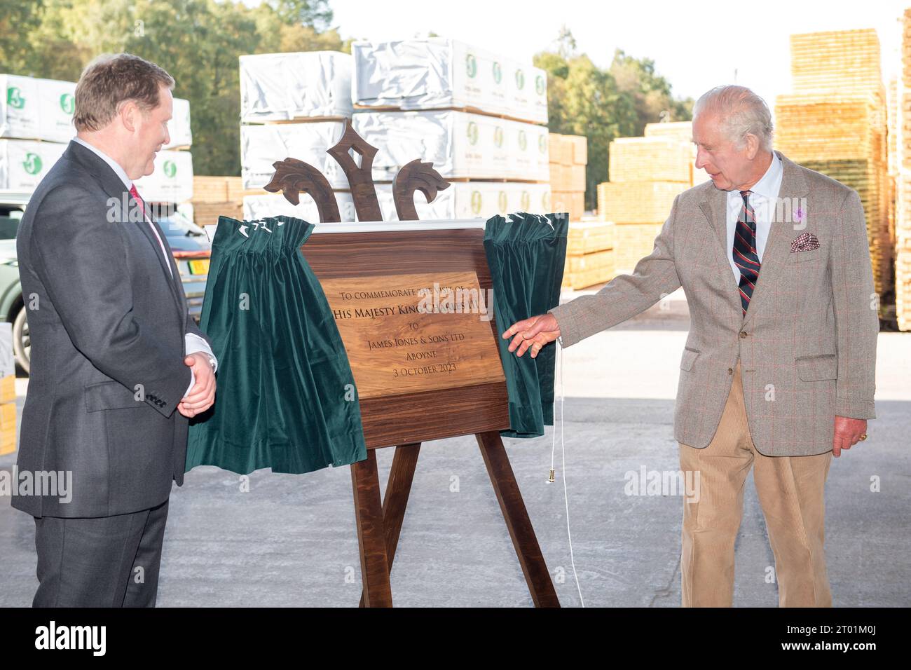 King Charles III unveils a plaque alongside company chairman Tom Bruce ...