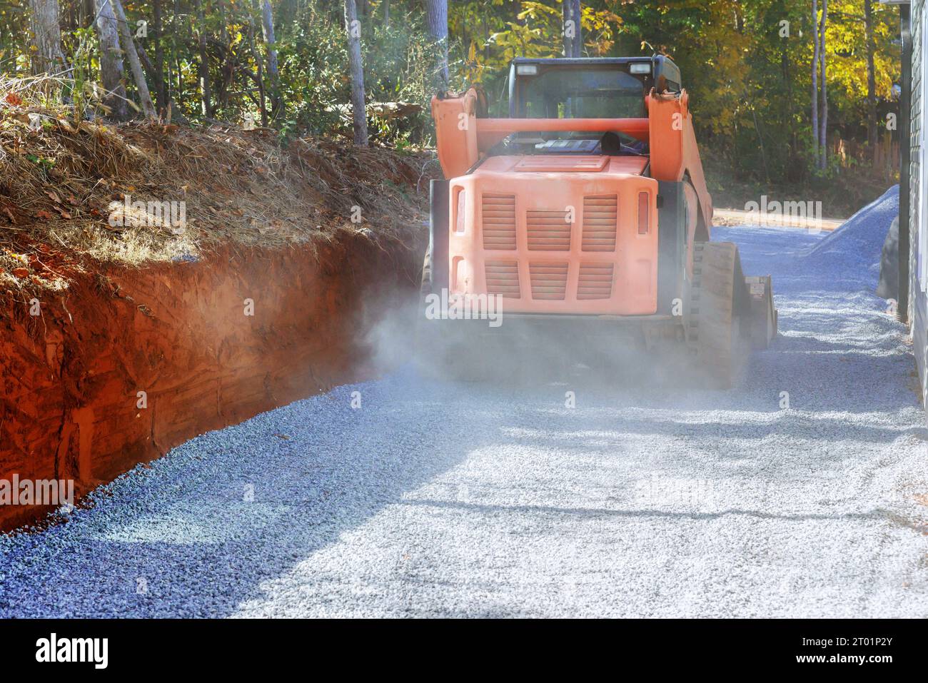 Using tractor to lay crushed stone gravel fill on top surface of new ...