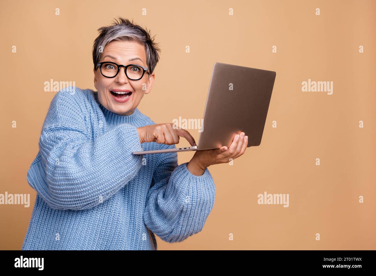 Portrait of astonished positive person use wireless netbook finger ...