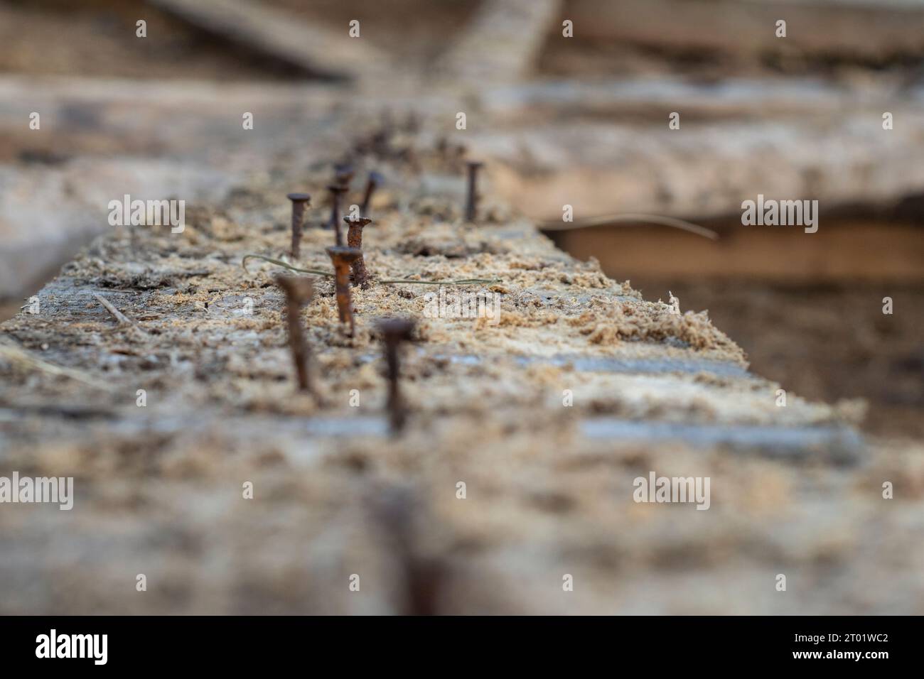 Old, damaged wooden beams lie with rusty nails stuck in after the ...