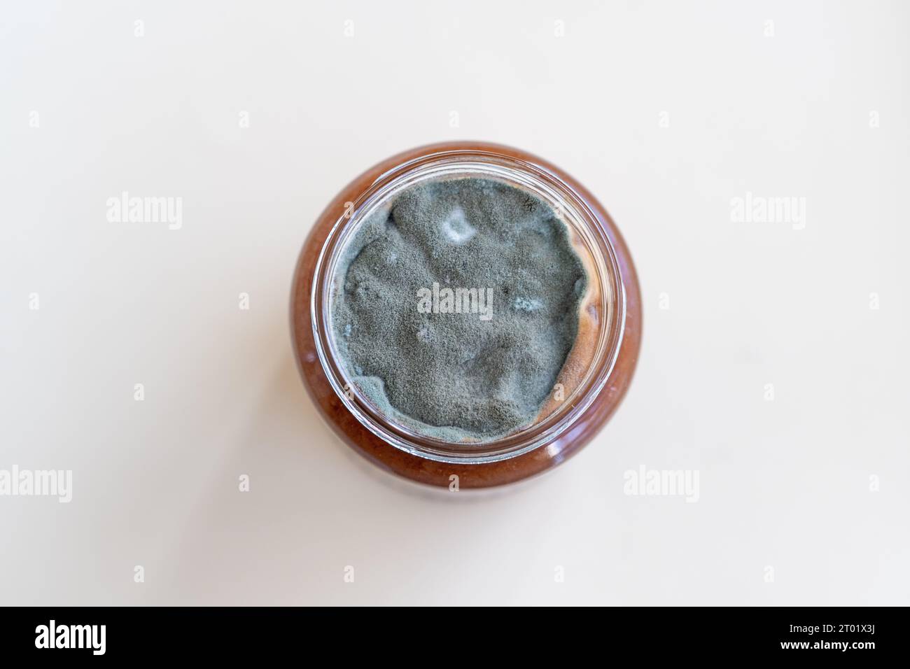 Open jar with sweet jam and mold on a white background Stock Photo - Alamy