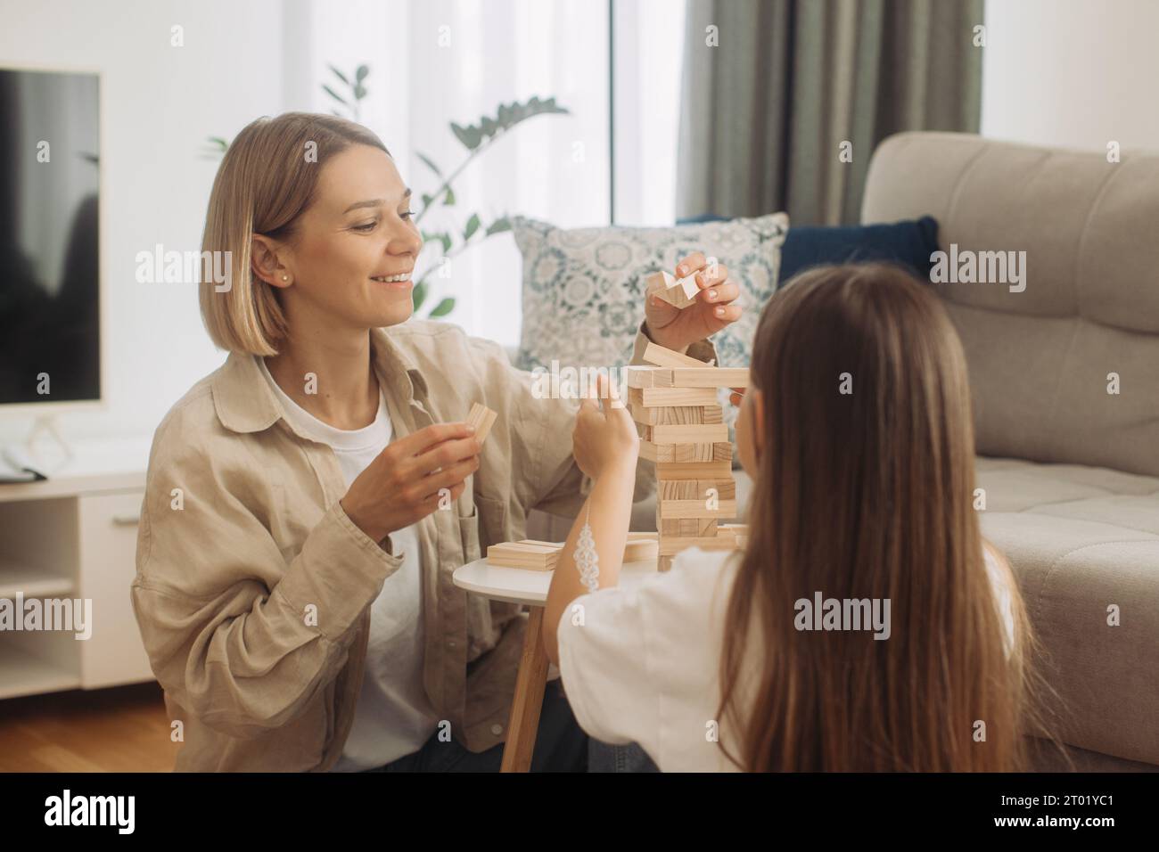 Family plays board game. Cheerful and friendly young woman and her ...