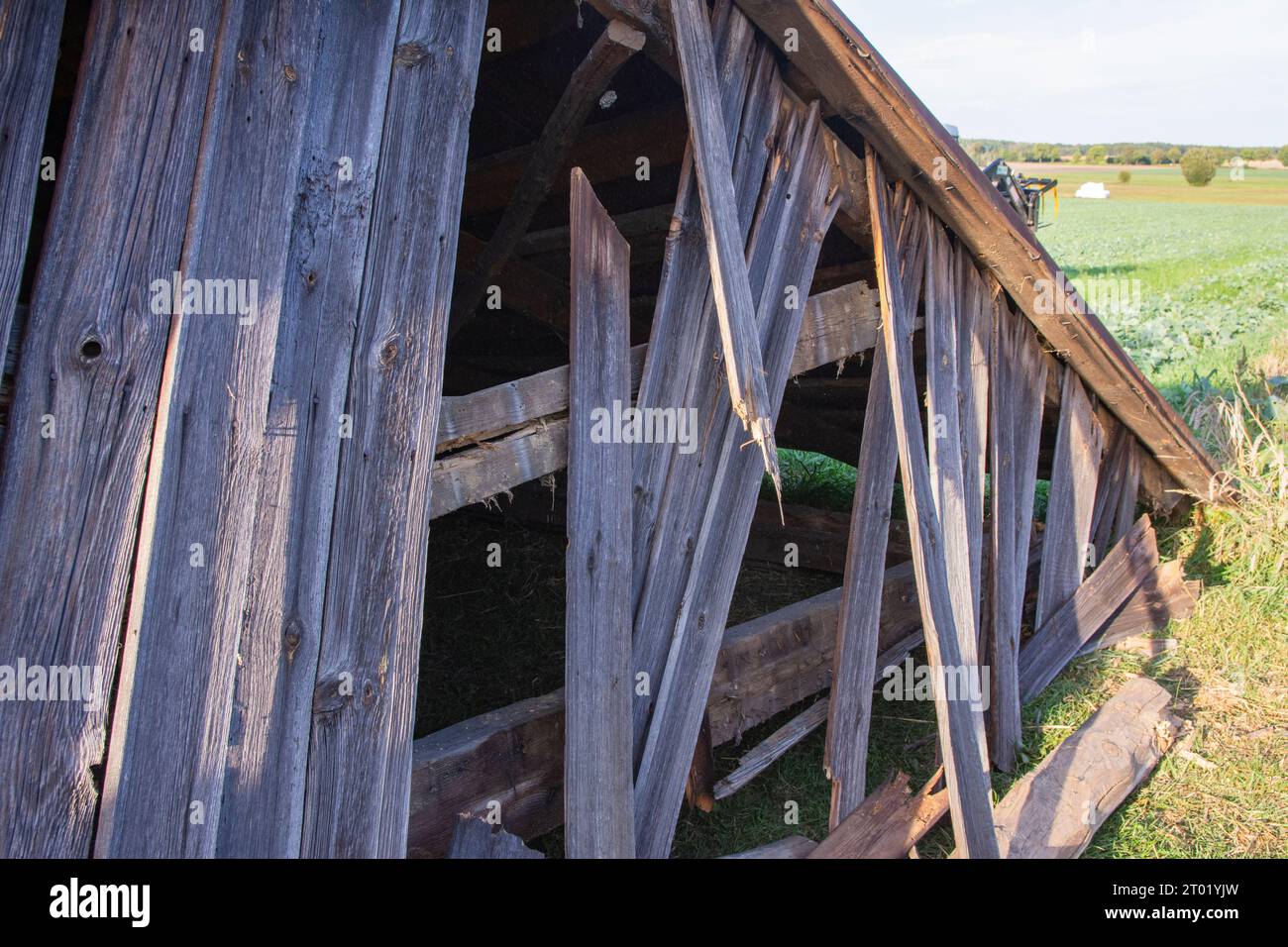 The remains of an old, destroyed roof lie on the ground after the ...