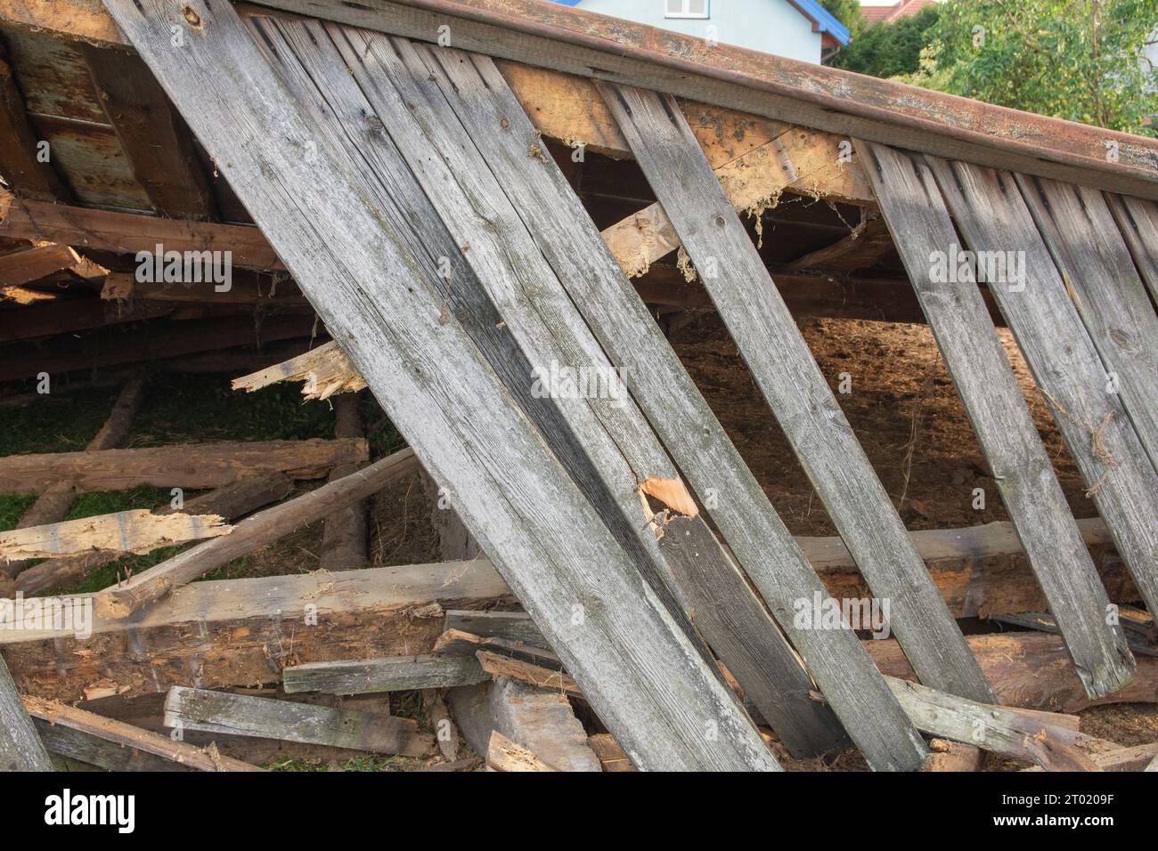 The remains of an old, destroyed roof lie on the ground after the demolition of the barn. Day ...