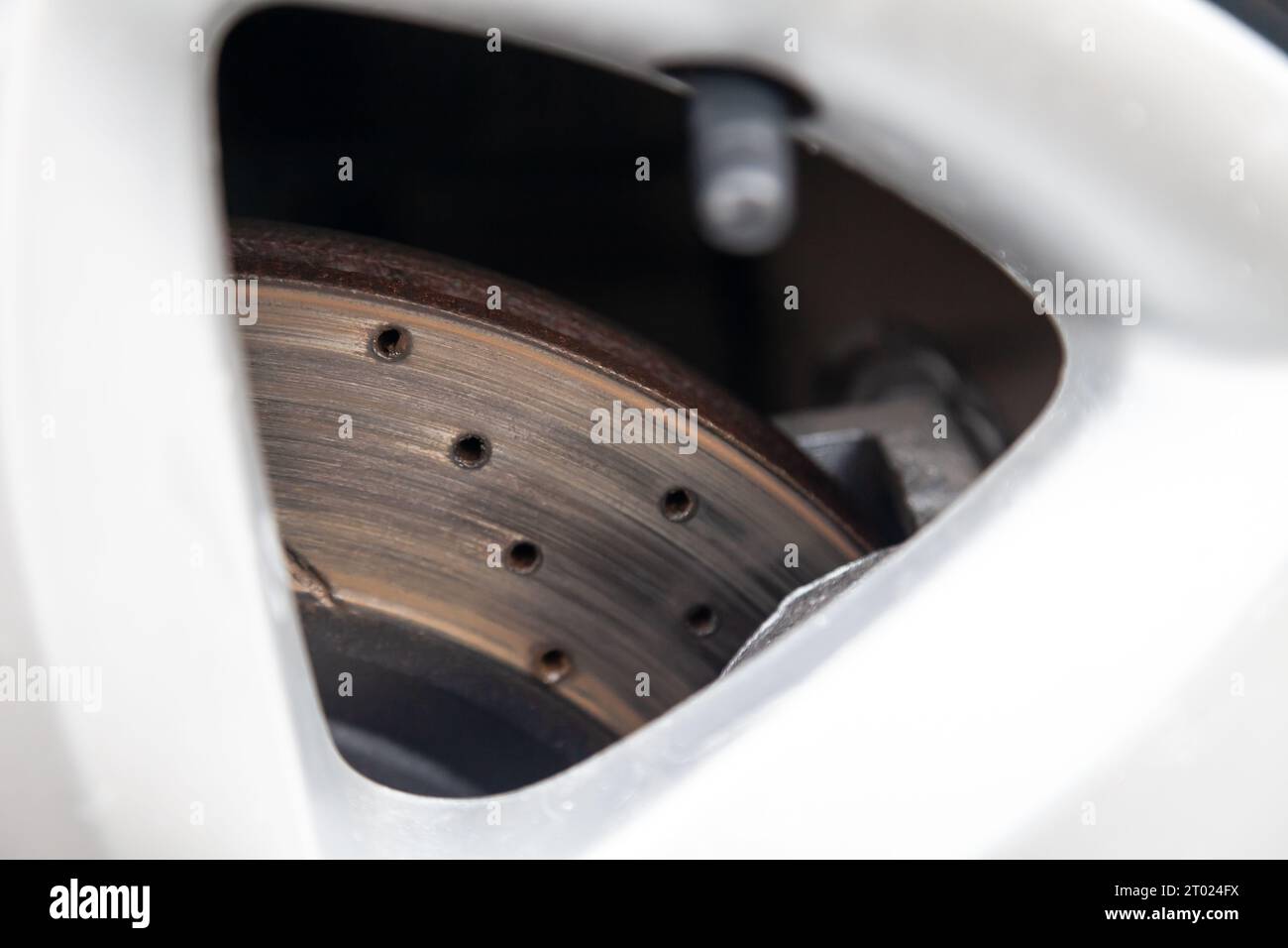 Close-up on a part of an aluminum wheel through the spokes of which a ...