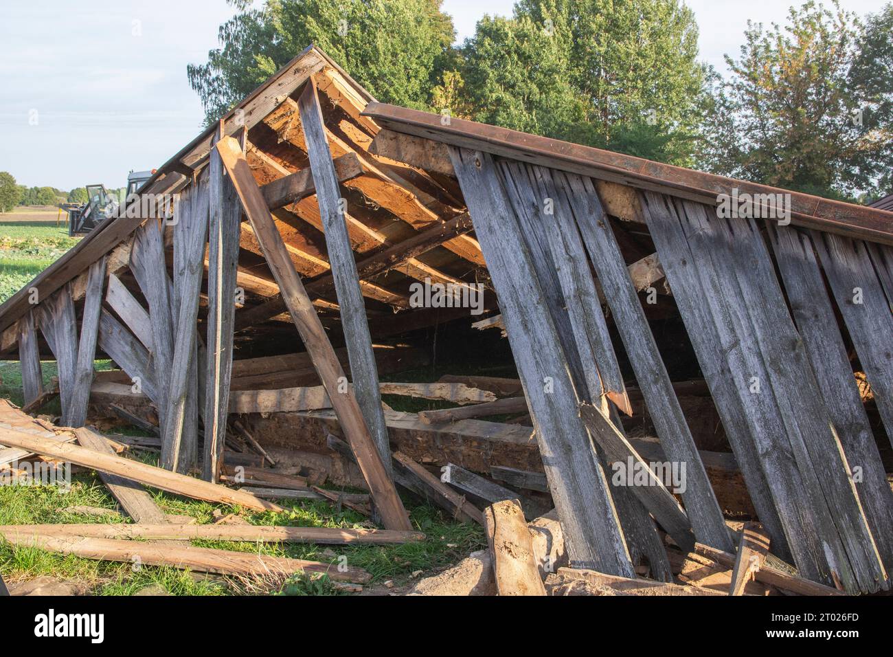 The remains of an old, destroyed metal roof lie on the ground after the ...