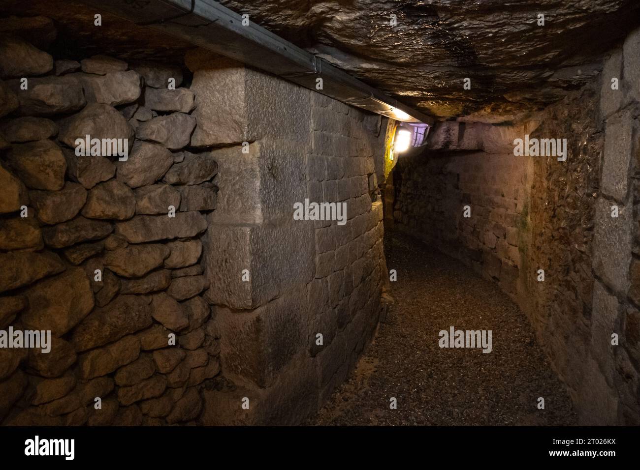 In the Paris Catacombs, a long underground path with structures formed by human bones, near ...