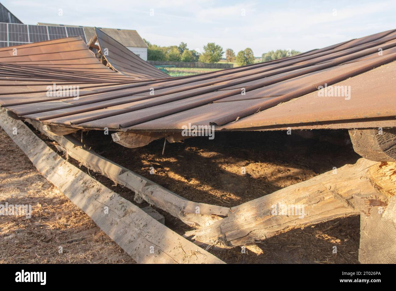 The remains of an old, destroyed metal roof lie on the ground after the ...