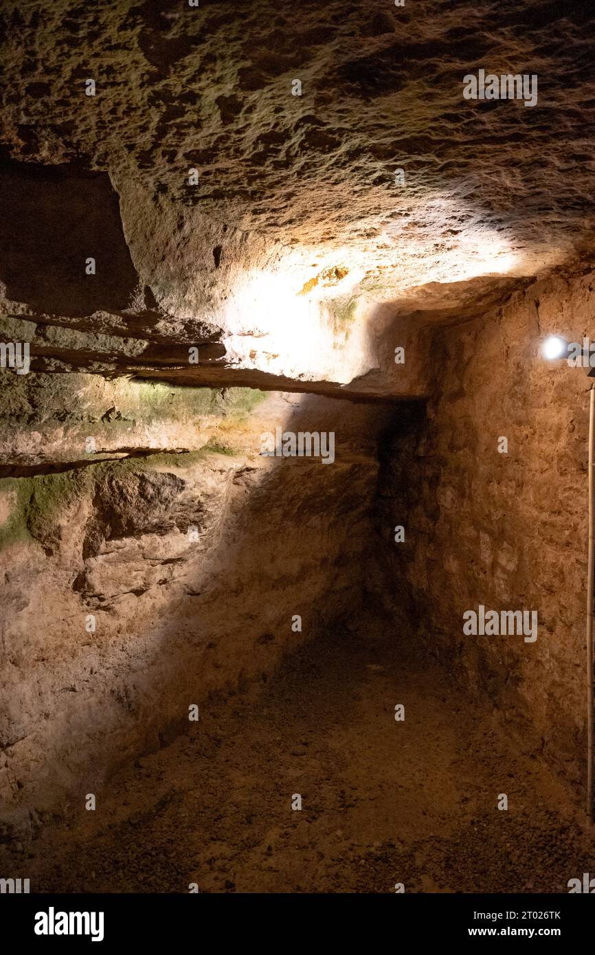 In the Paris Catacombs, a long underground path with structures formed ...