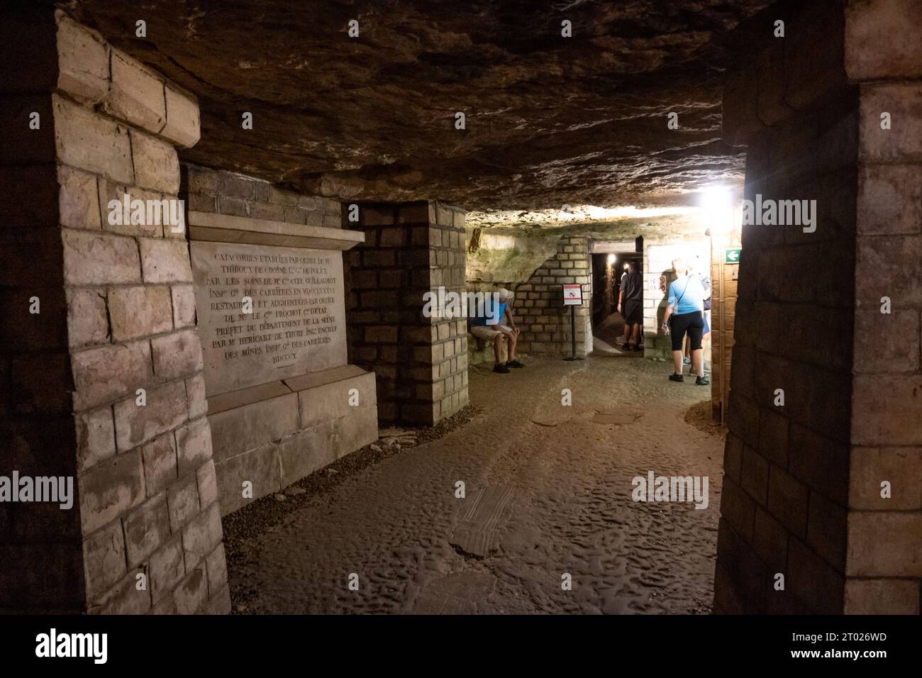 In the Paris Catacombs, a long underground path with structures formed ...