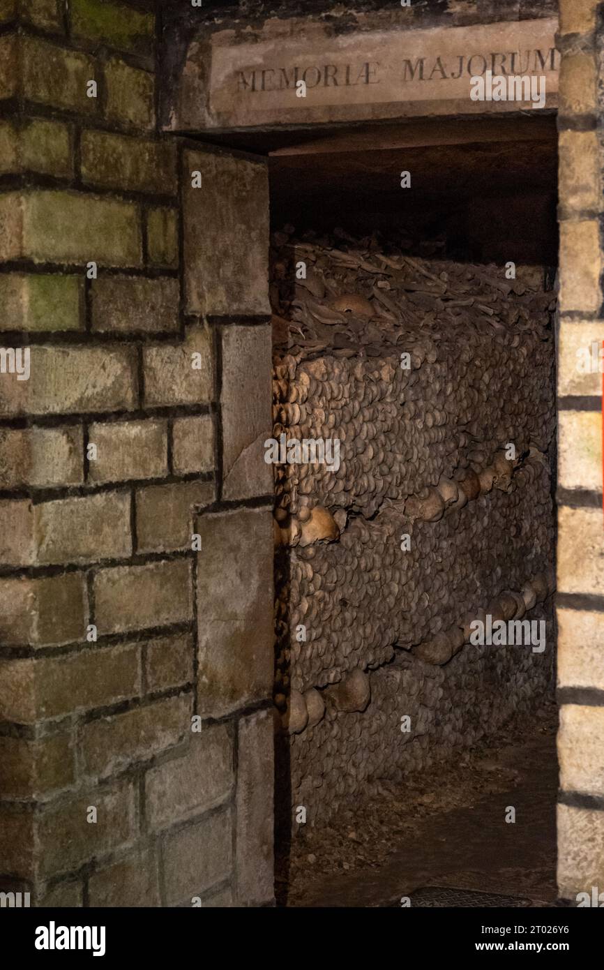 In the Paris Catacombs, a long underground path with structures formed ...