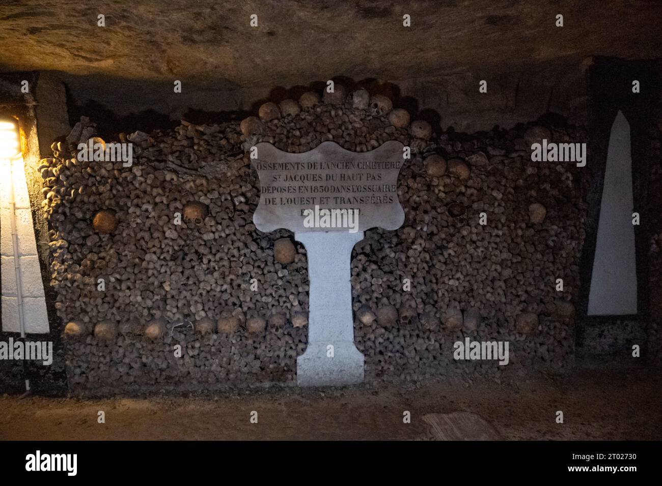 In the Paris Catacombs, a long underground path with structures formed ...