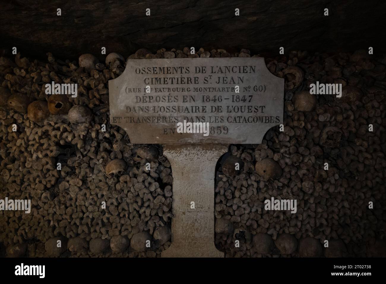 In the Paris Catacombs, a long underground path with structures formed ...