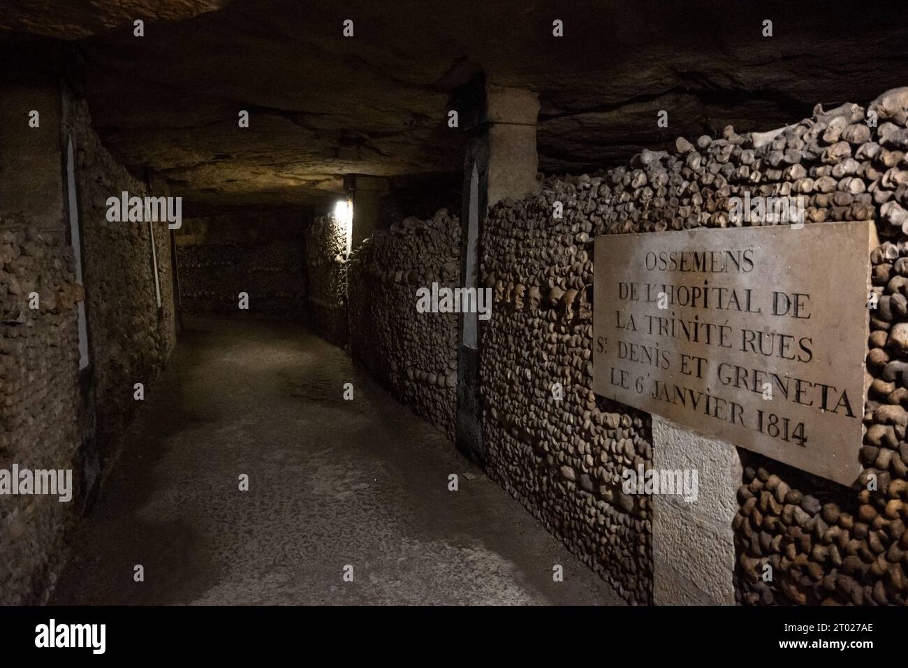 In the Paris Catacombs, a long underground path with structures formed ...