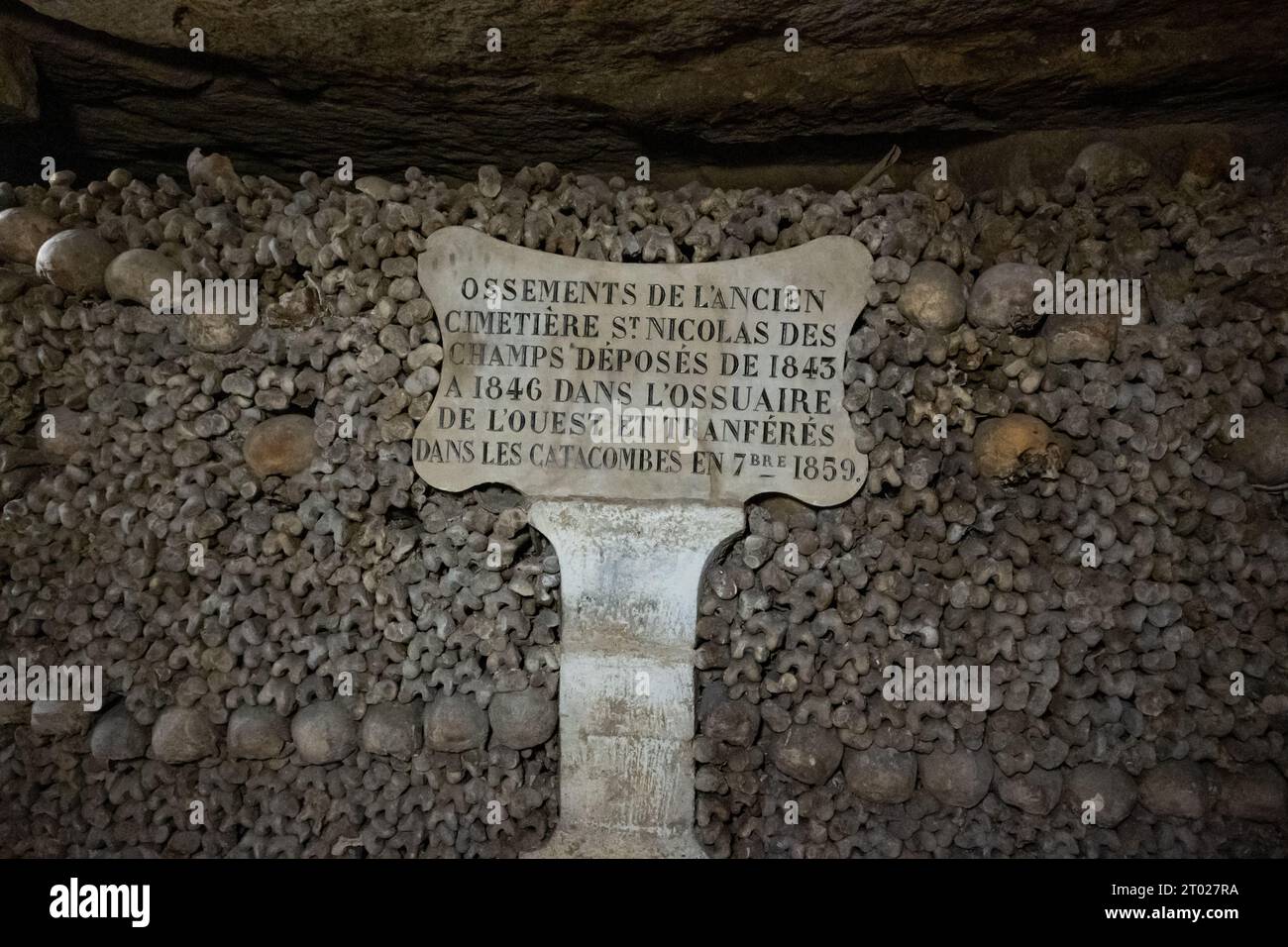 In the Paris Catacombs, a long underground path with structures formed ...