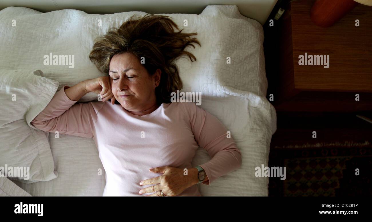 Older woman getting up from bed. person gets up from nap Stock Photo ...