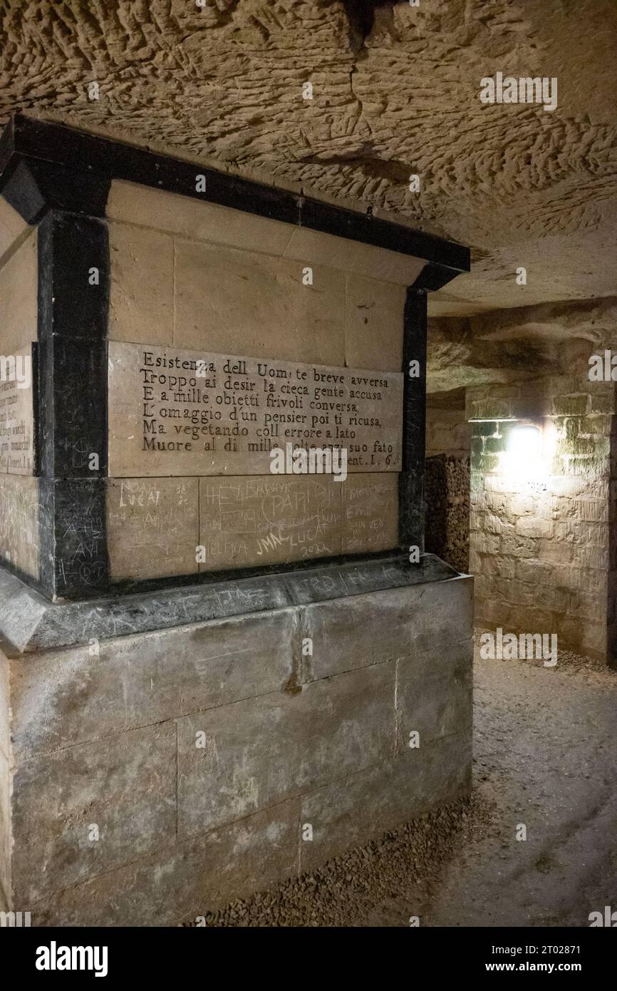 In the Paris Catacombs, a long underground path with structures formed ...