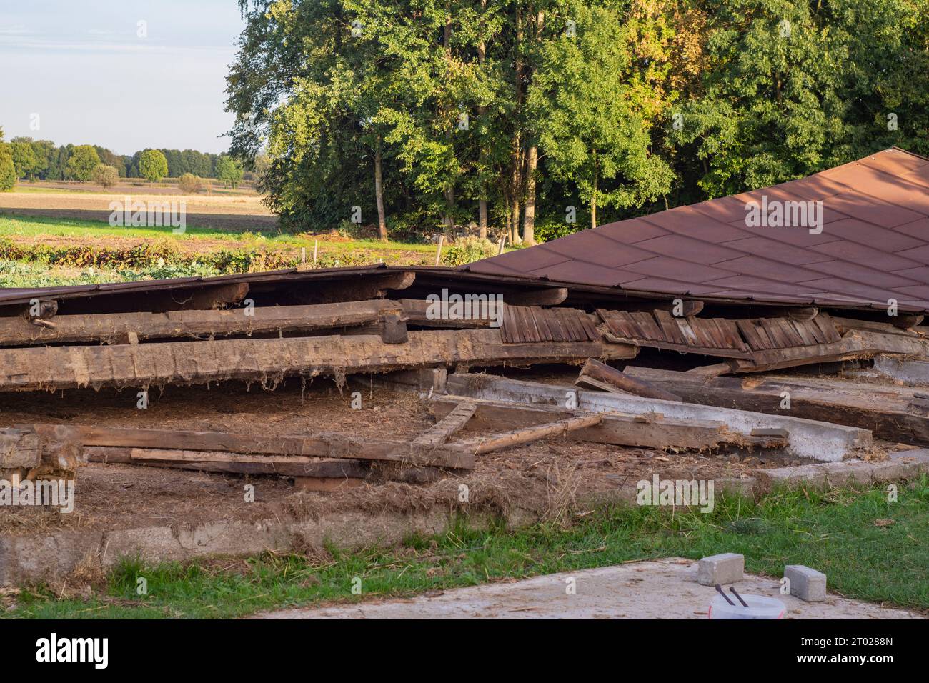 The remains of an old, destroyed metal roof lie on the ground after the ...