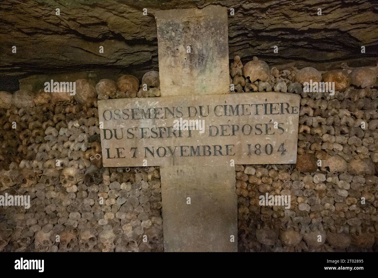 In the Paris Catacombs, a long underground path with structures formed ...