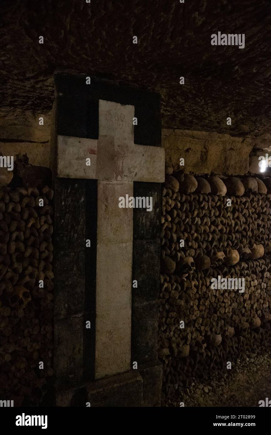 In the Paris Catacombs, a long underground path with structures formed ...