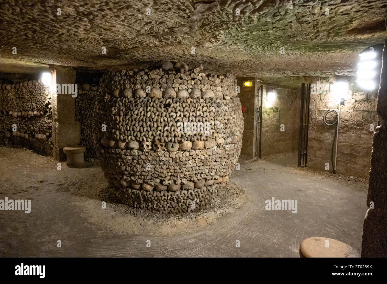 In the Paris Catacombs, a long underground path with structures formed ...
