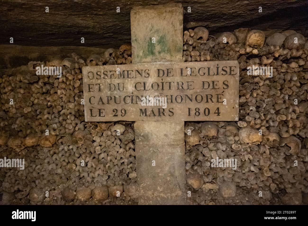 In the Paris Catacombs, a long underground path with structures formed ...