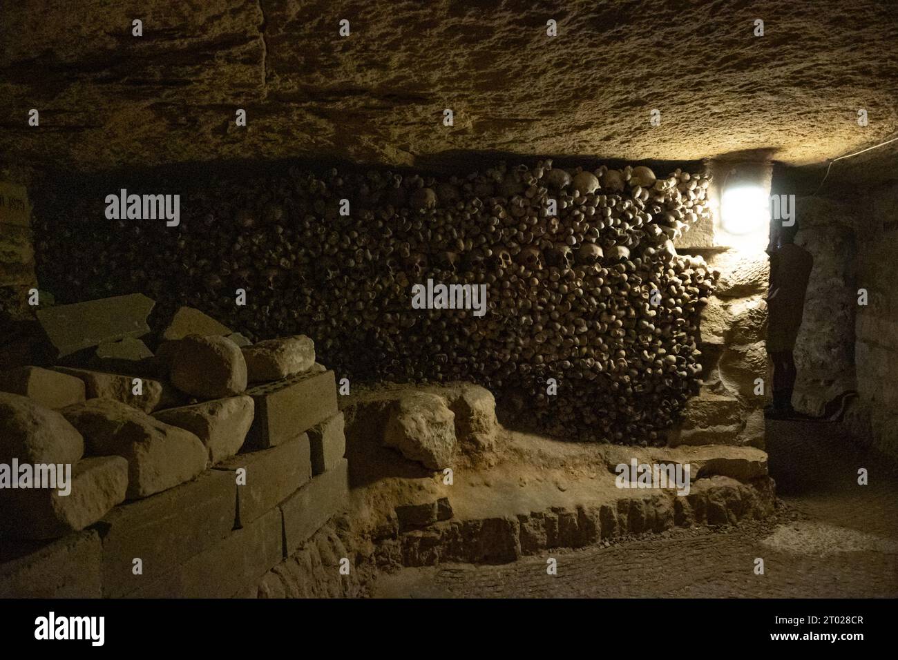 In the Paris Catacombs, a long underground path with structures formed ...