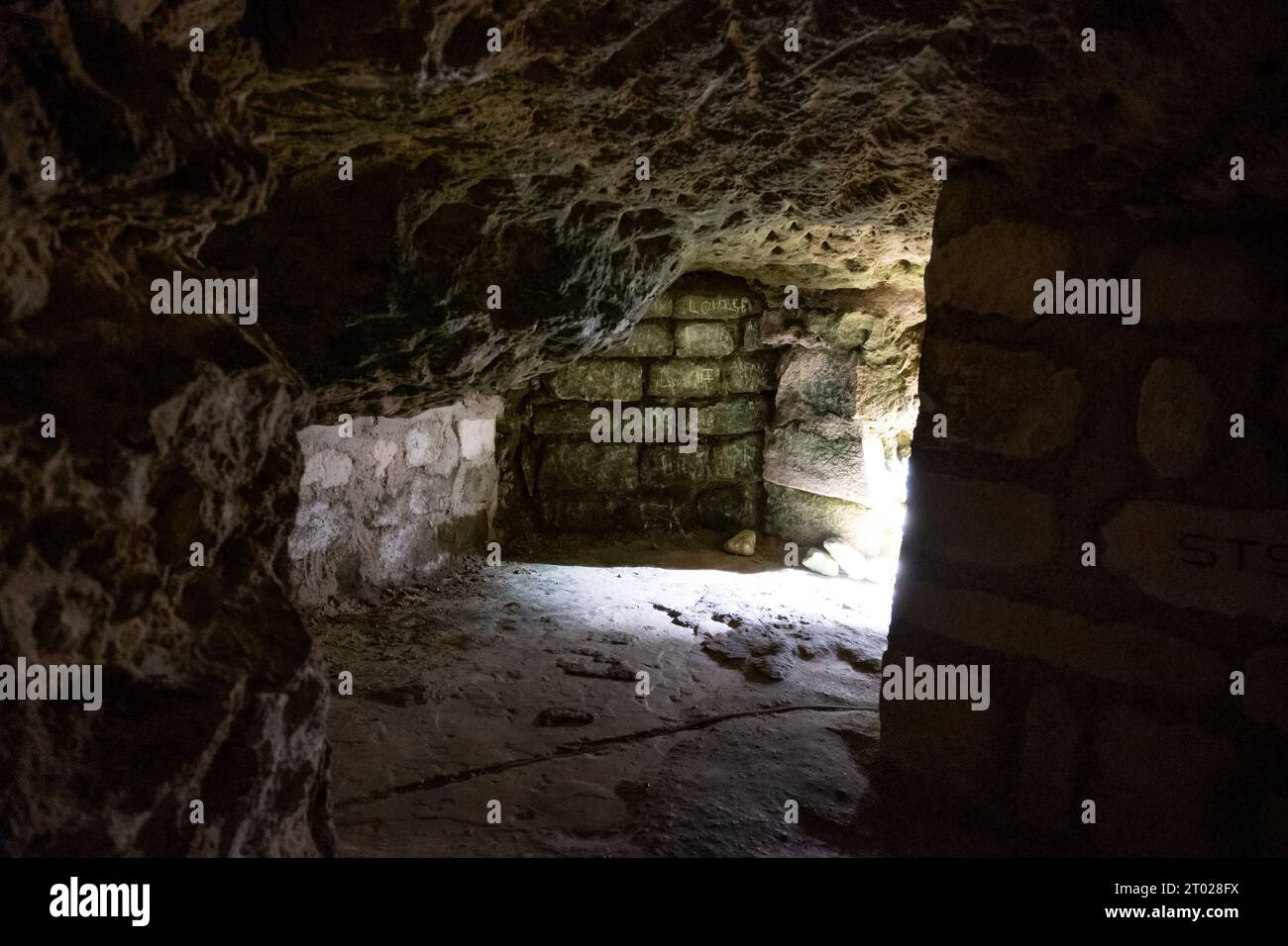 In the Paris Catacombs, a long underground path with structures formed ...