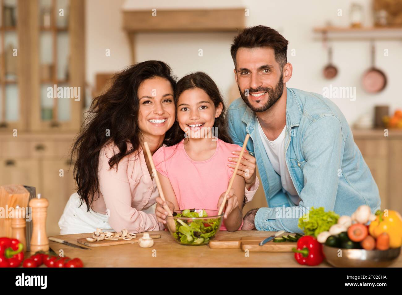 Happy european family cooking together and smiling to camera, parents ...