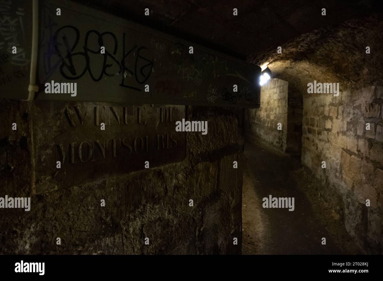 In the Paris Catacombs, a long underground path with structures formed ...