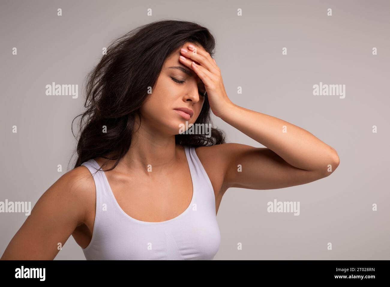 Sad millennial middle eastern woman with long hair touches head Stock ...